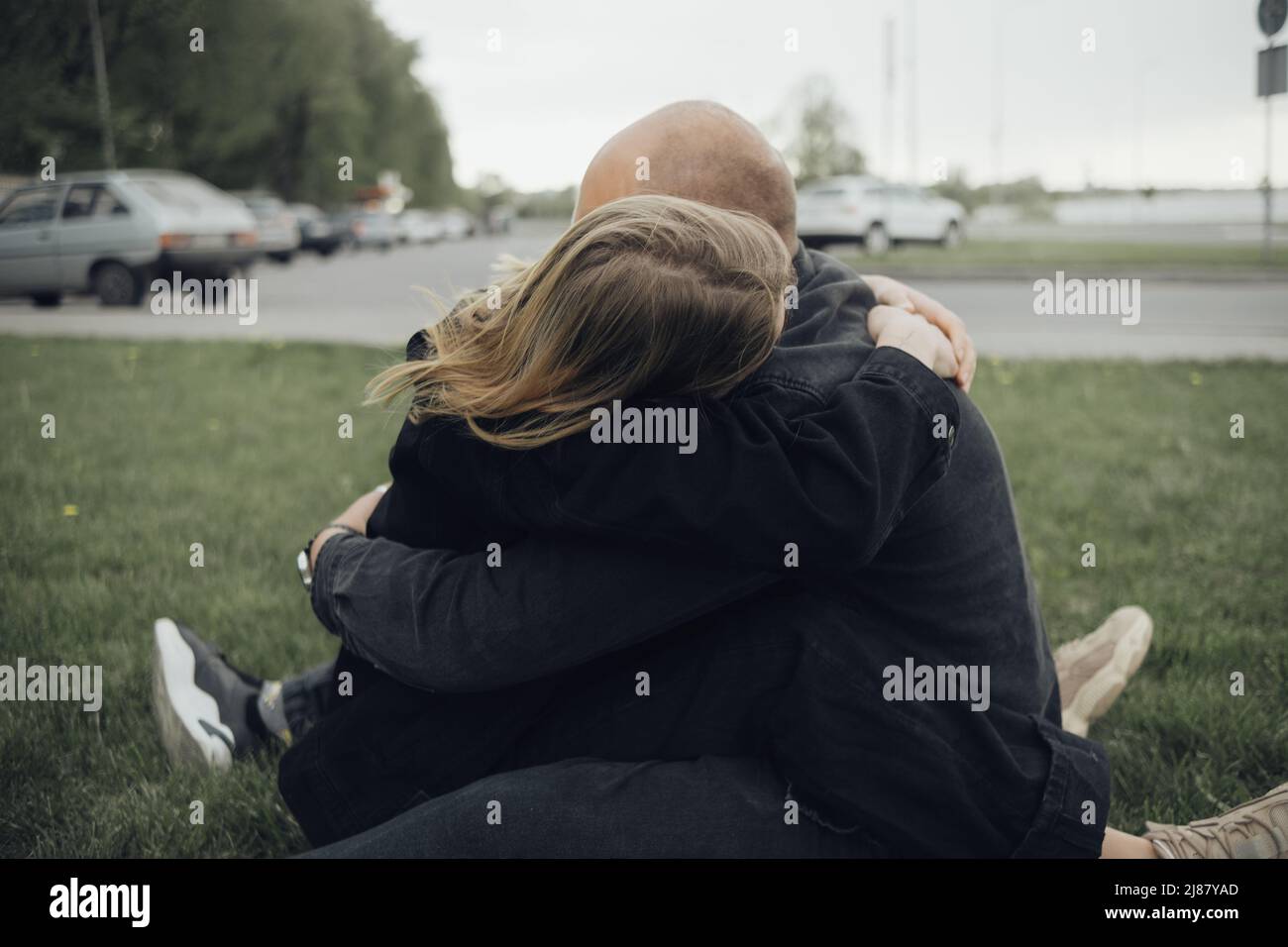 lovers hug tightly sitting on the grass Stock Photo - Alamy