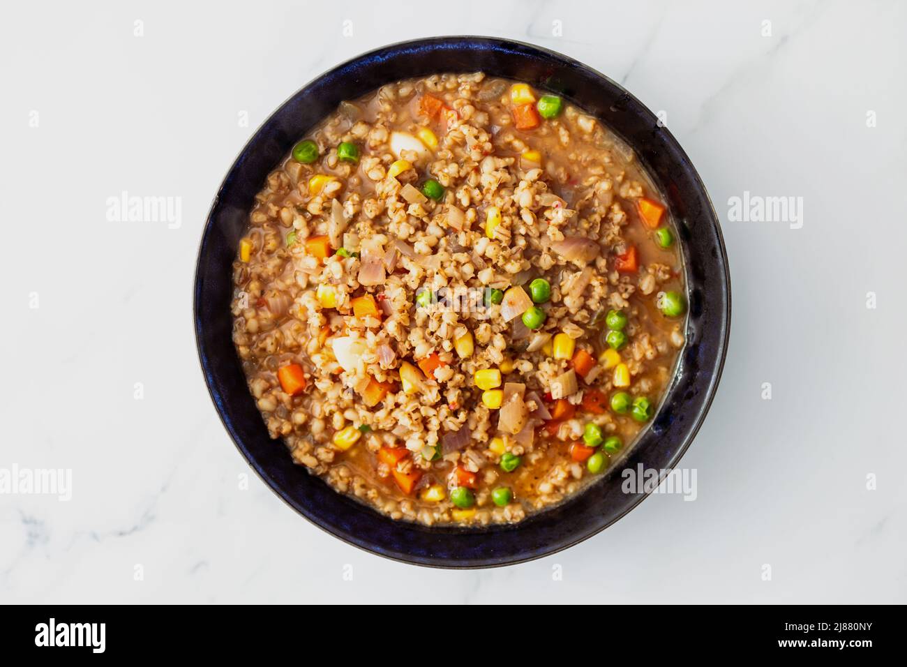 vegan barley minestrone soup with peas carrots and corn in savoury ...