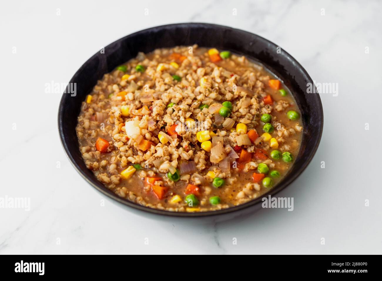 vegan barley minestrone soup with peas carrots and corn in savoury ...
