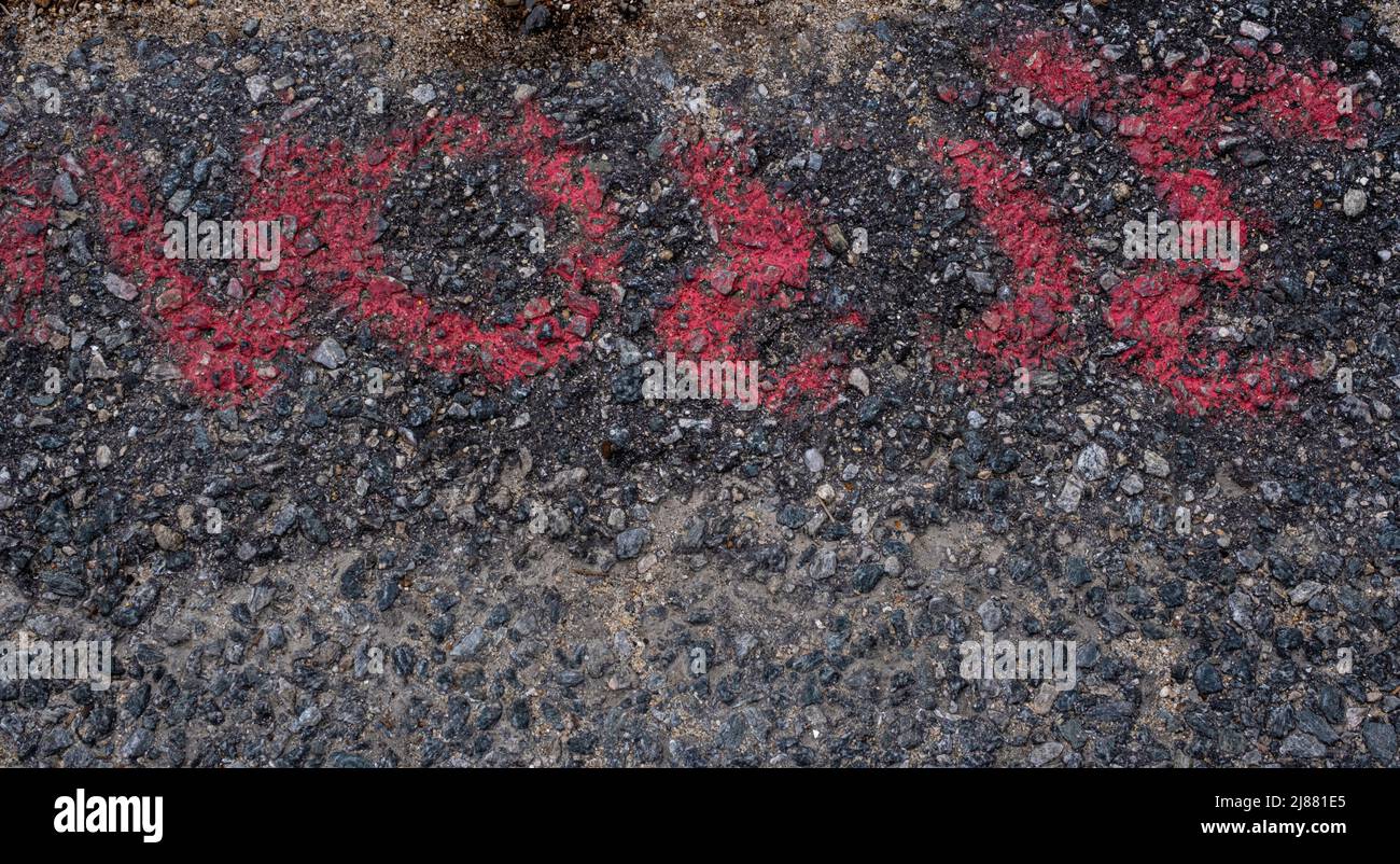 Red painted markings on black and brown gravel pavement background ...