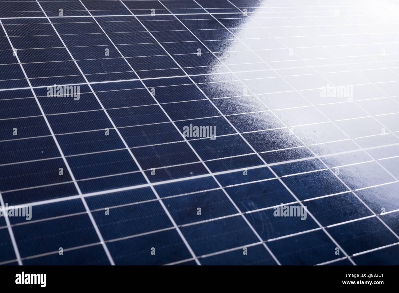 High angle close-up of sunlight falling on blue solar panel, copy space ...
