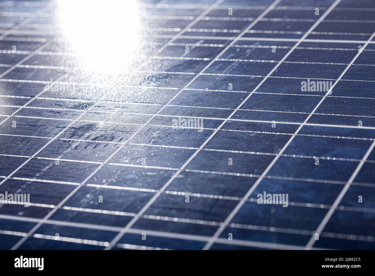 High angle close-up of sunlight falling on solar panel with white grid ...