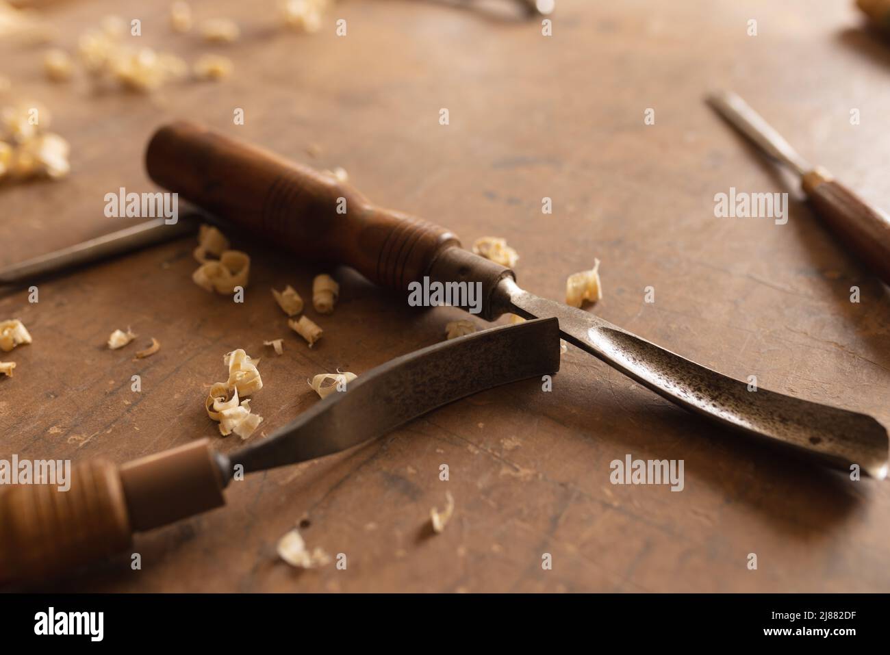 Close-up of various hand tools with wood shavings on workbench in ...