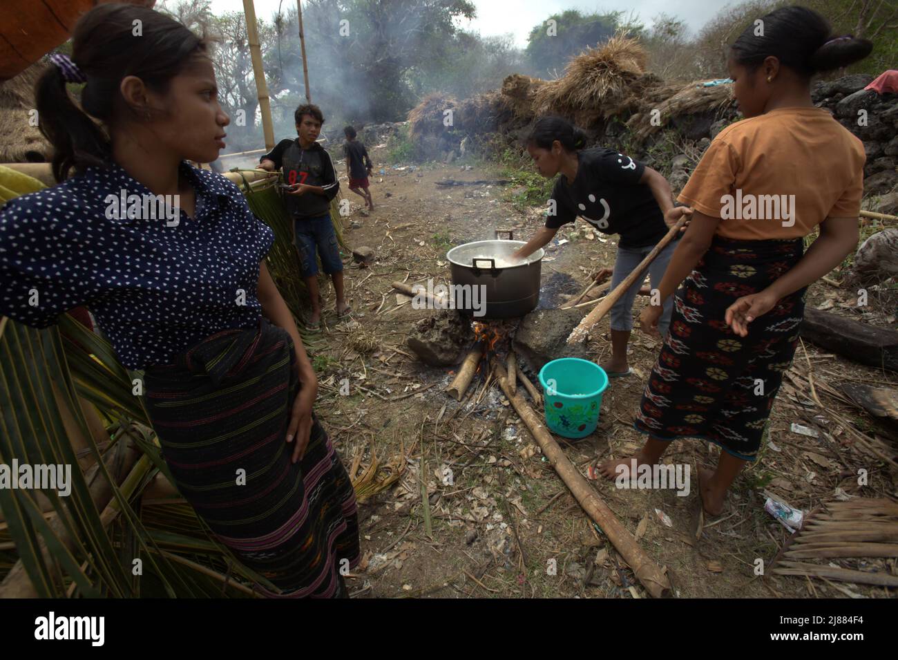 Women boiling water as a preparation for a ritual of house construction ...