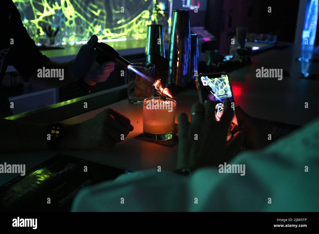 New York, USA. 13th May, 2022. A bartender uses a kitchen blow torch to ...