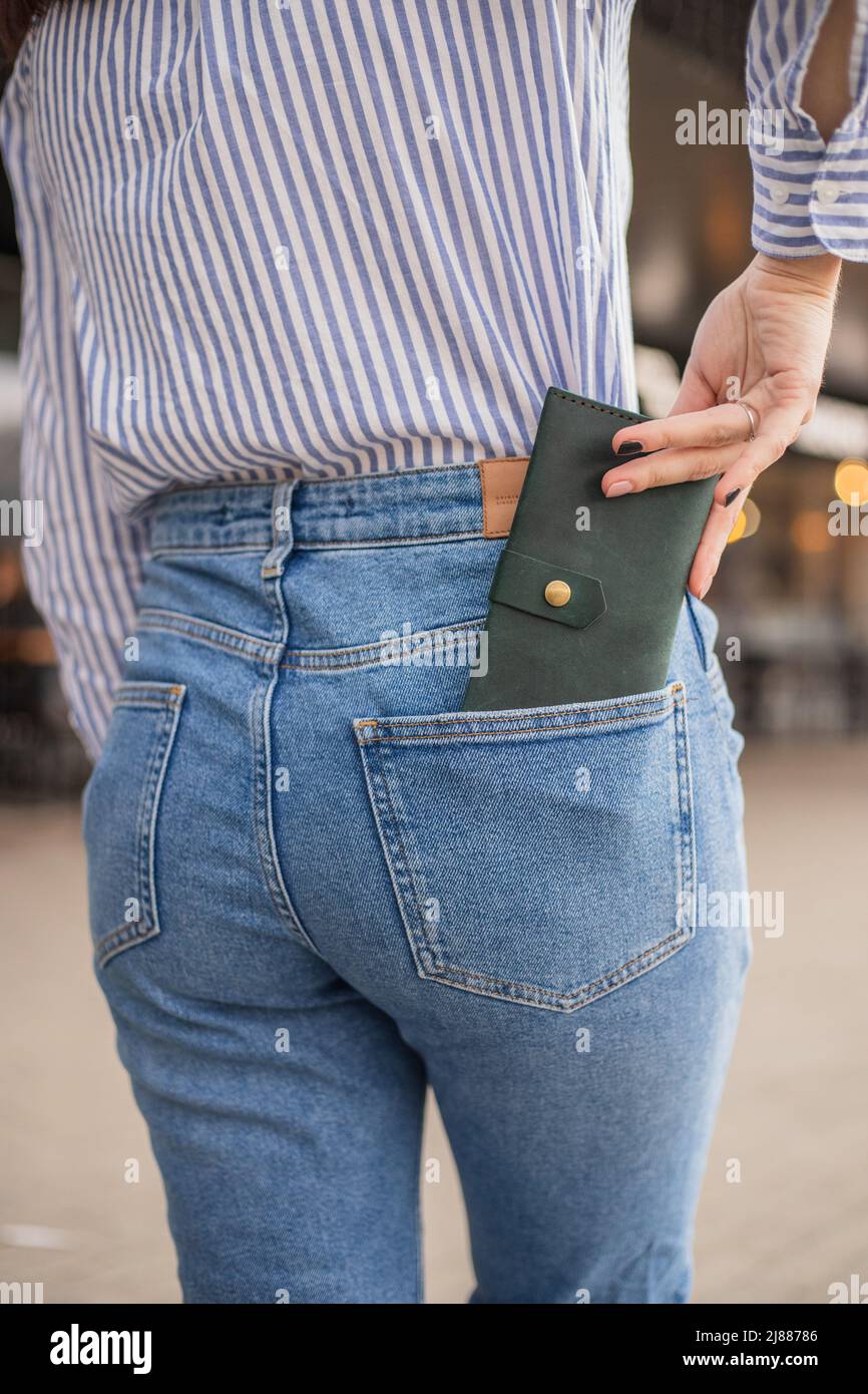 Confident woman posing in save keeping your wallet in the back pocket ...