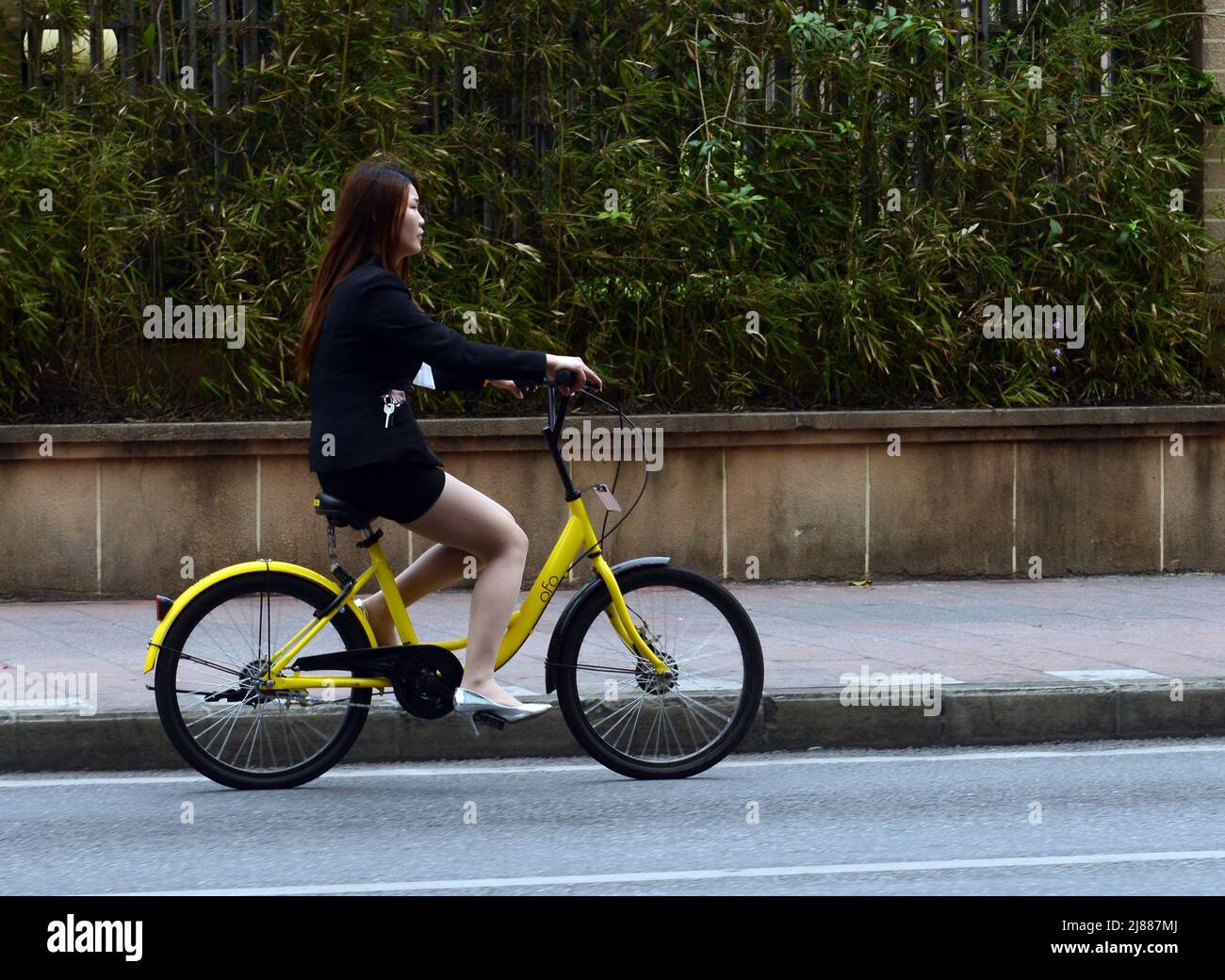 A Chinese woman riding her bicycle in Shenzhen, China Stock Photo - Alamy