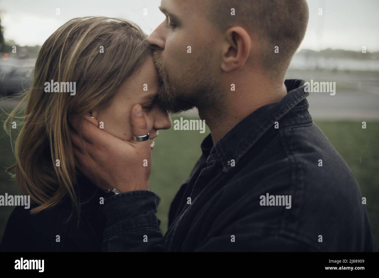 guy gently kisses his beloved holding hands on her face Stock Photo - Alamy