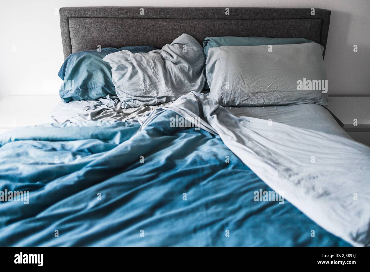 queen size bed lookng messy on one side and tidy on the other with ...