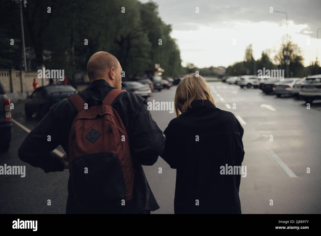 the lovers are coming. view from the back. the guy has a backpack on ...