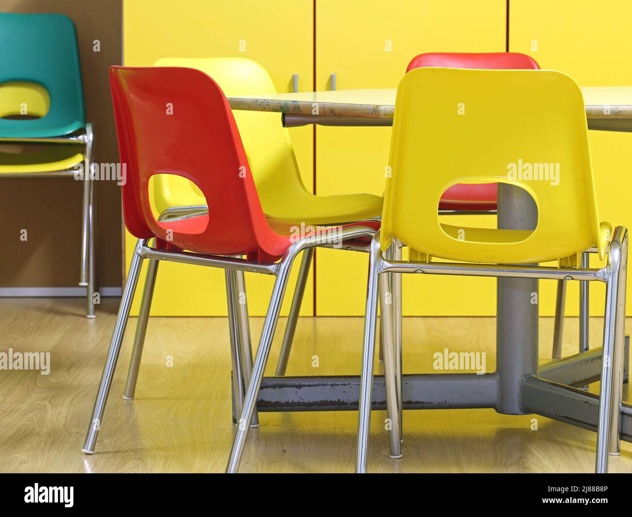 classroom of a kindergarten with small chairs and a hexagonal table ...
