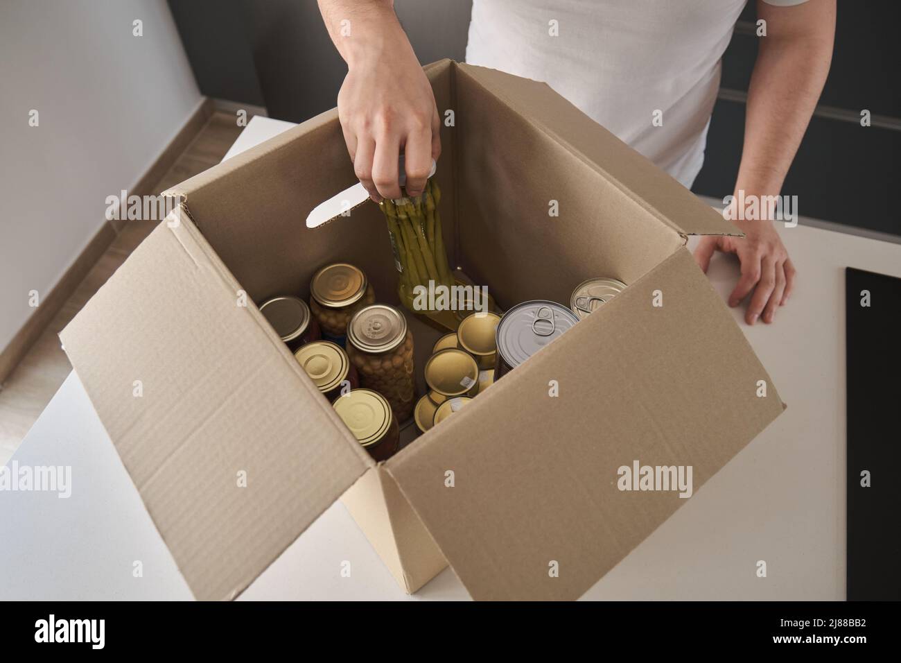 Unrecognizable man filling donation box with non-perishable food Stock ...