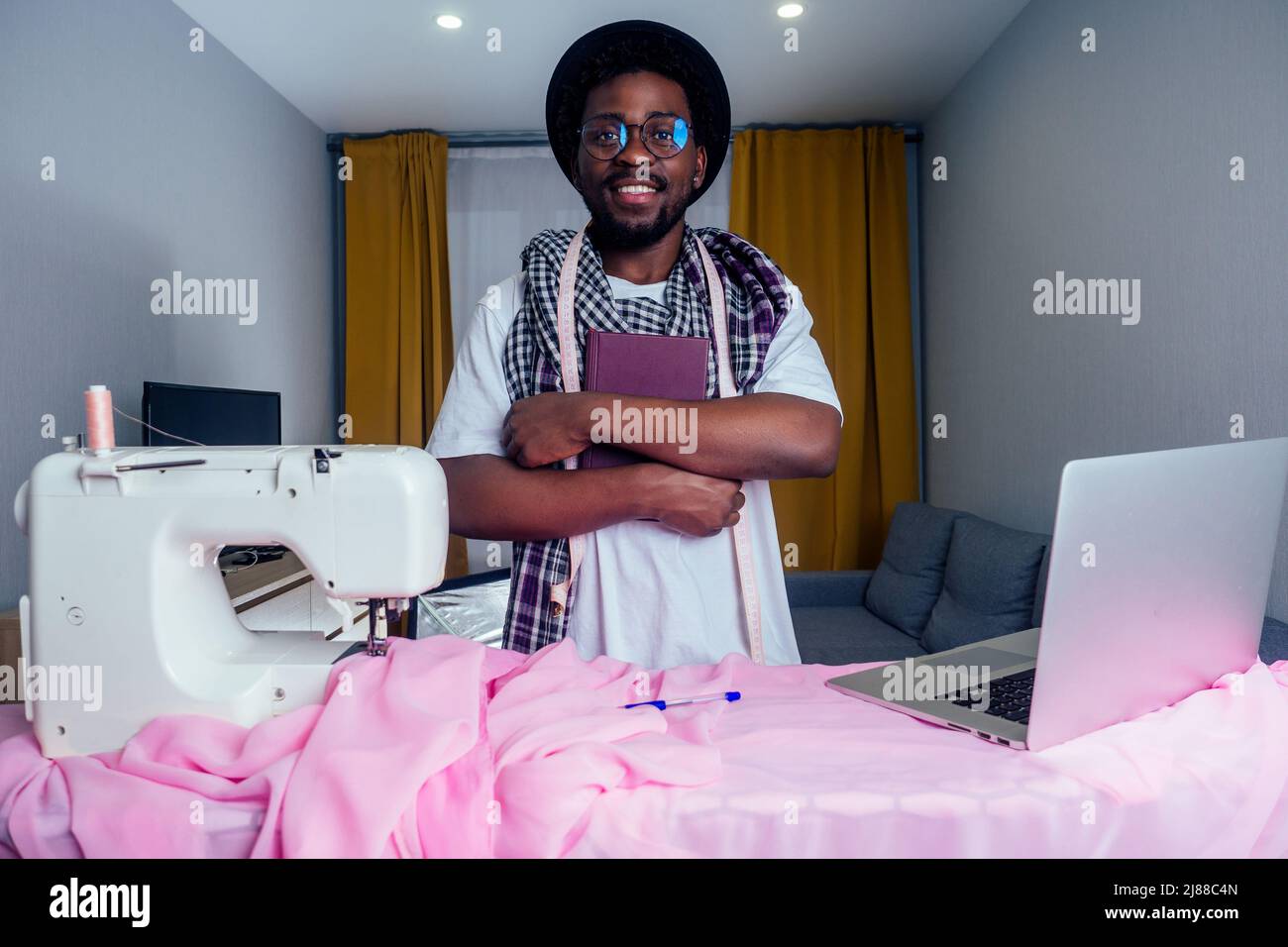 portrait of a handsome african man smiling seamstress with sewing ...