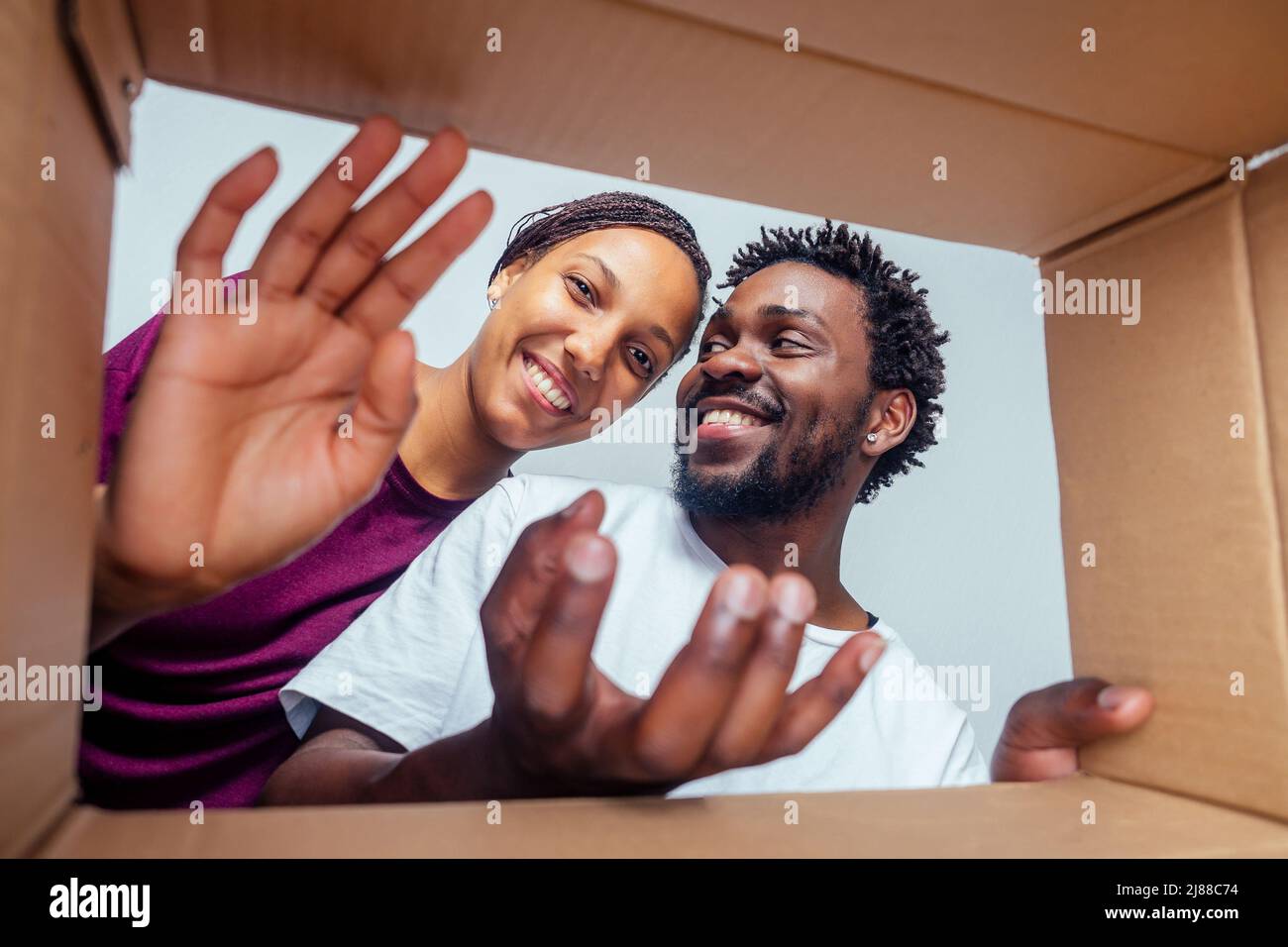 Bottom view of young fro american couple looking through the cardboard ...