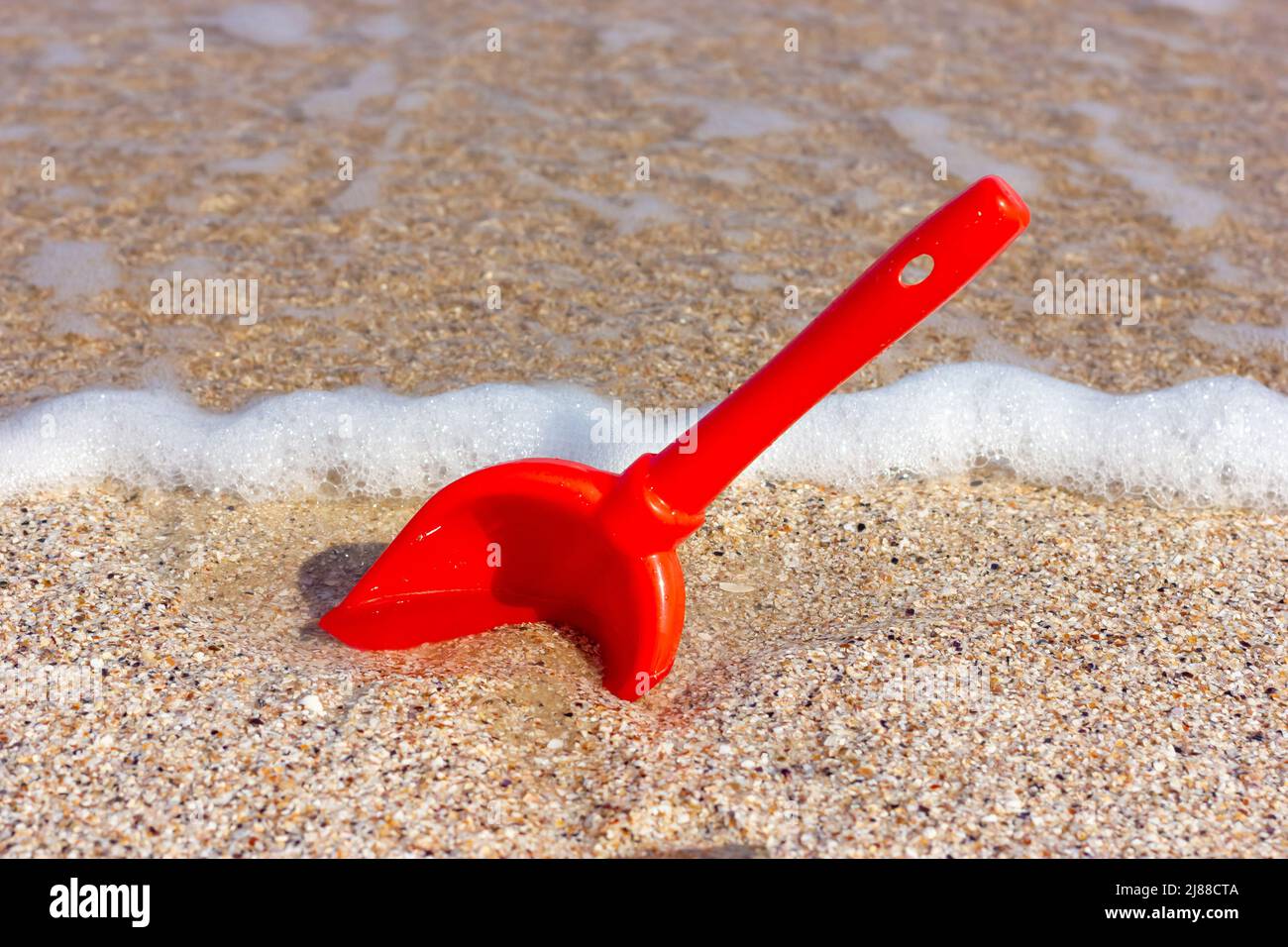 Red shovel in the sand on the seashore. Vacation on the beach Stock ...
