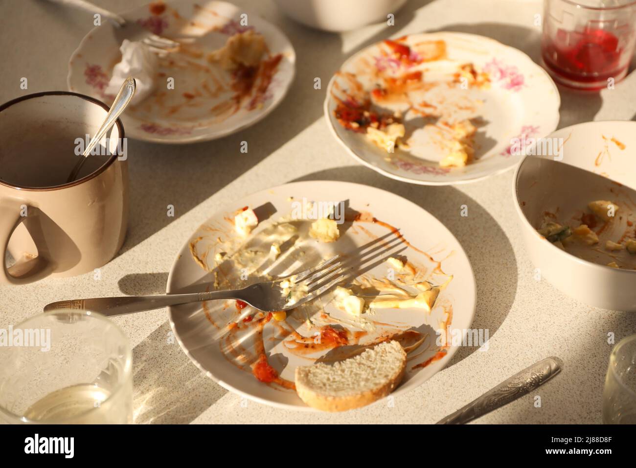 Empty dirty plates with spoons and forks on the table after meal ...