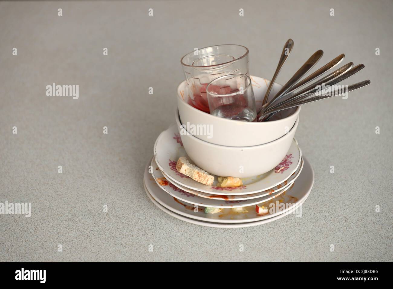 Stack of dirty dishes with food leftovers on the table after meal ...