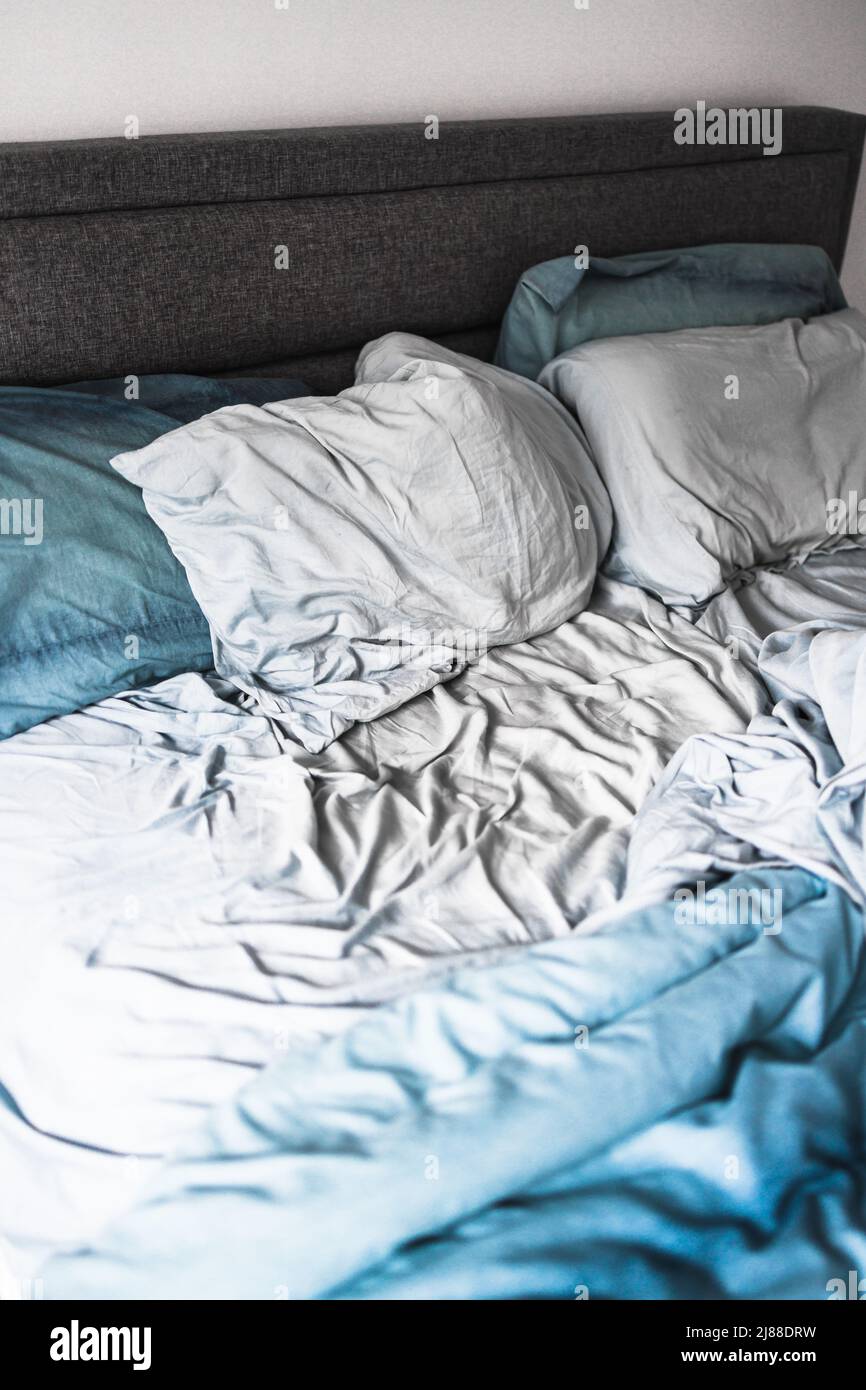 messy queen size bed with light blue quilt cover and sheets looking ...