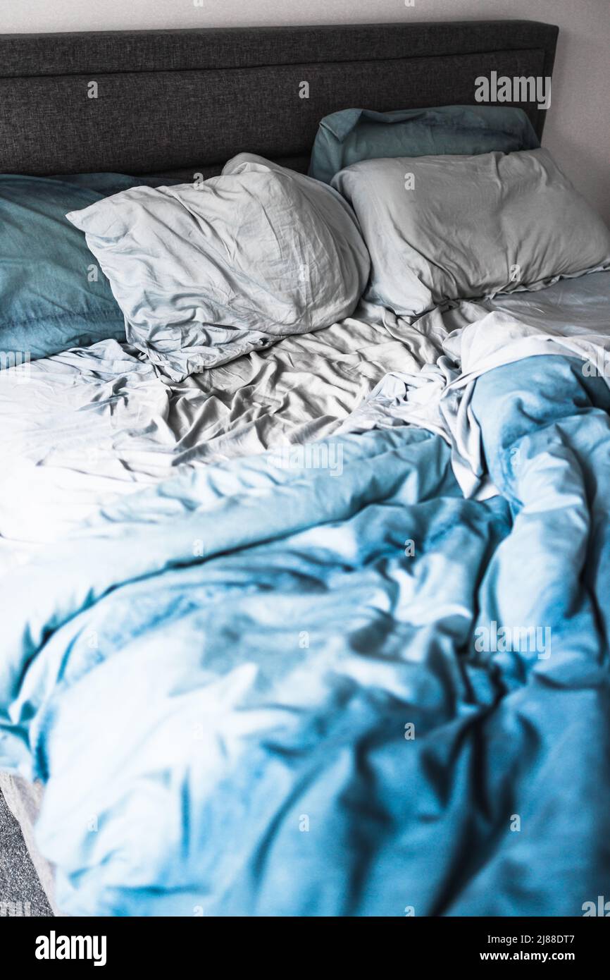 messy queen size bed with light blue quilt cover and sheets looking ...