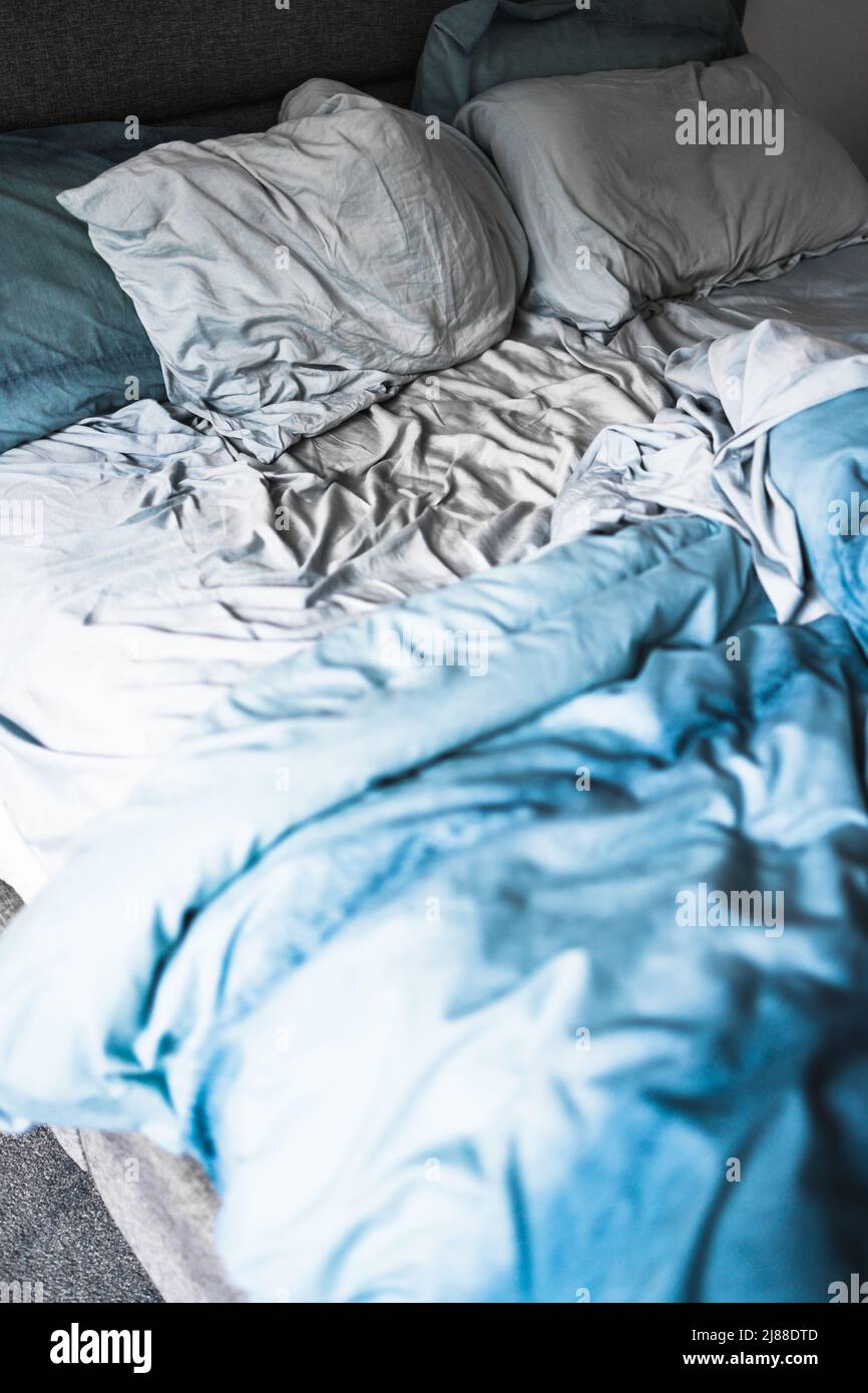 messy queen size bed with light blue quilt cover and sheets looking ...