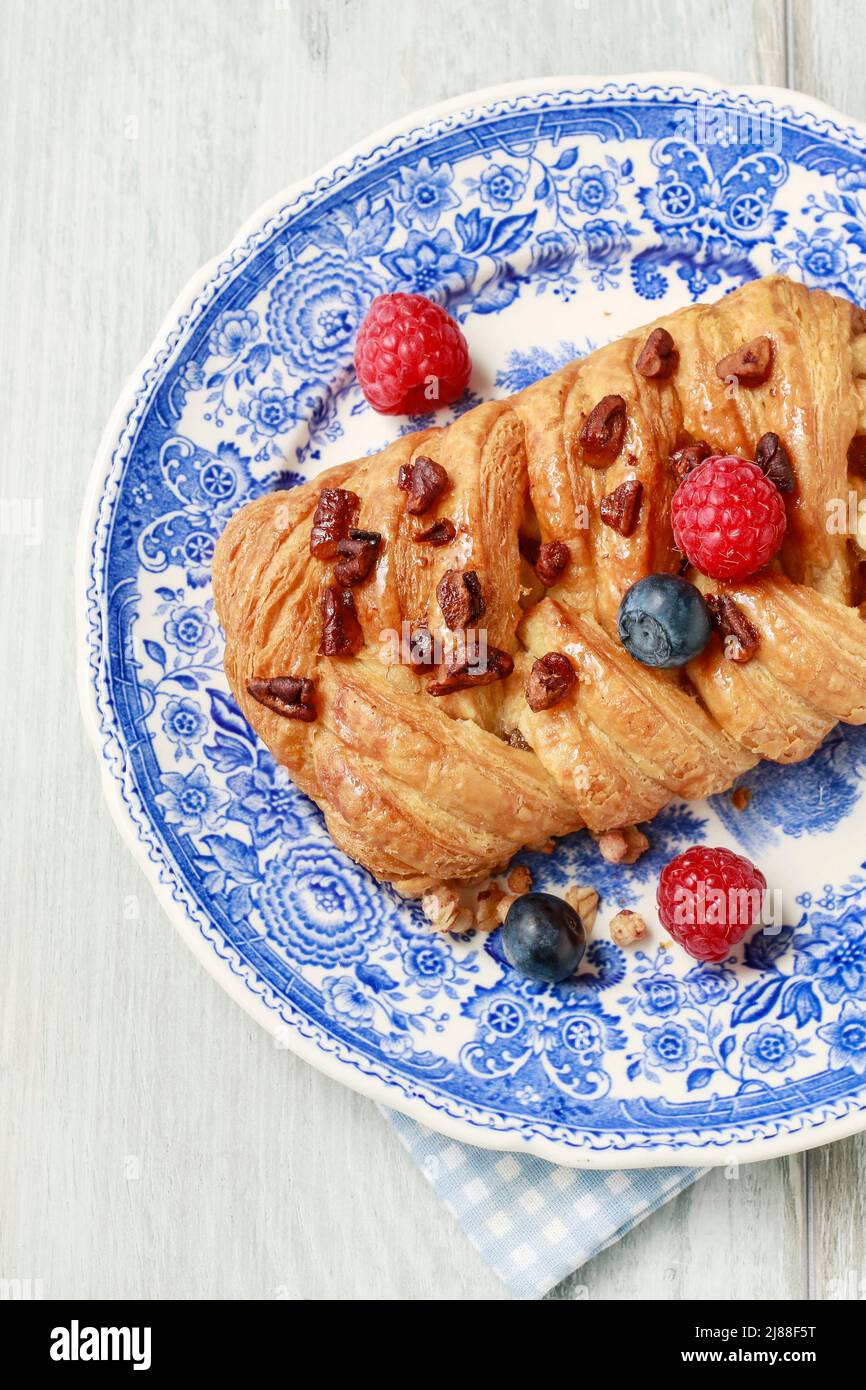Braided danish bun made of puff pastry decorated with fresh fruits ...
