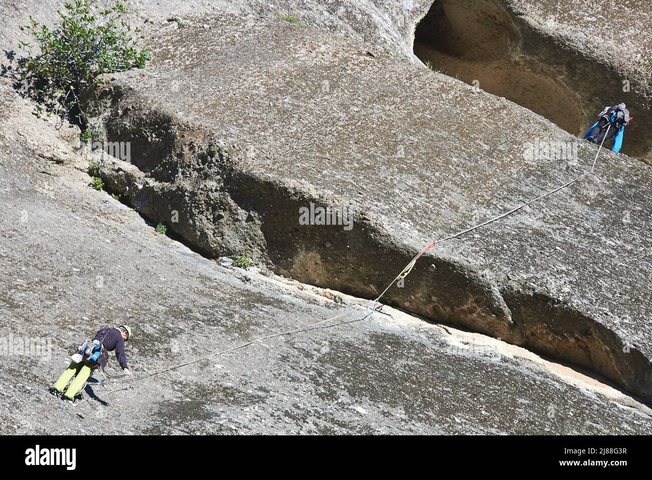 People climb the rocks of the Meteora monastery in the mountains of ...