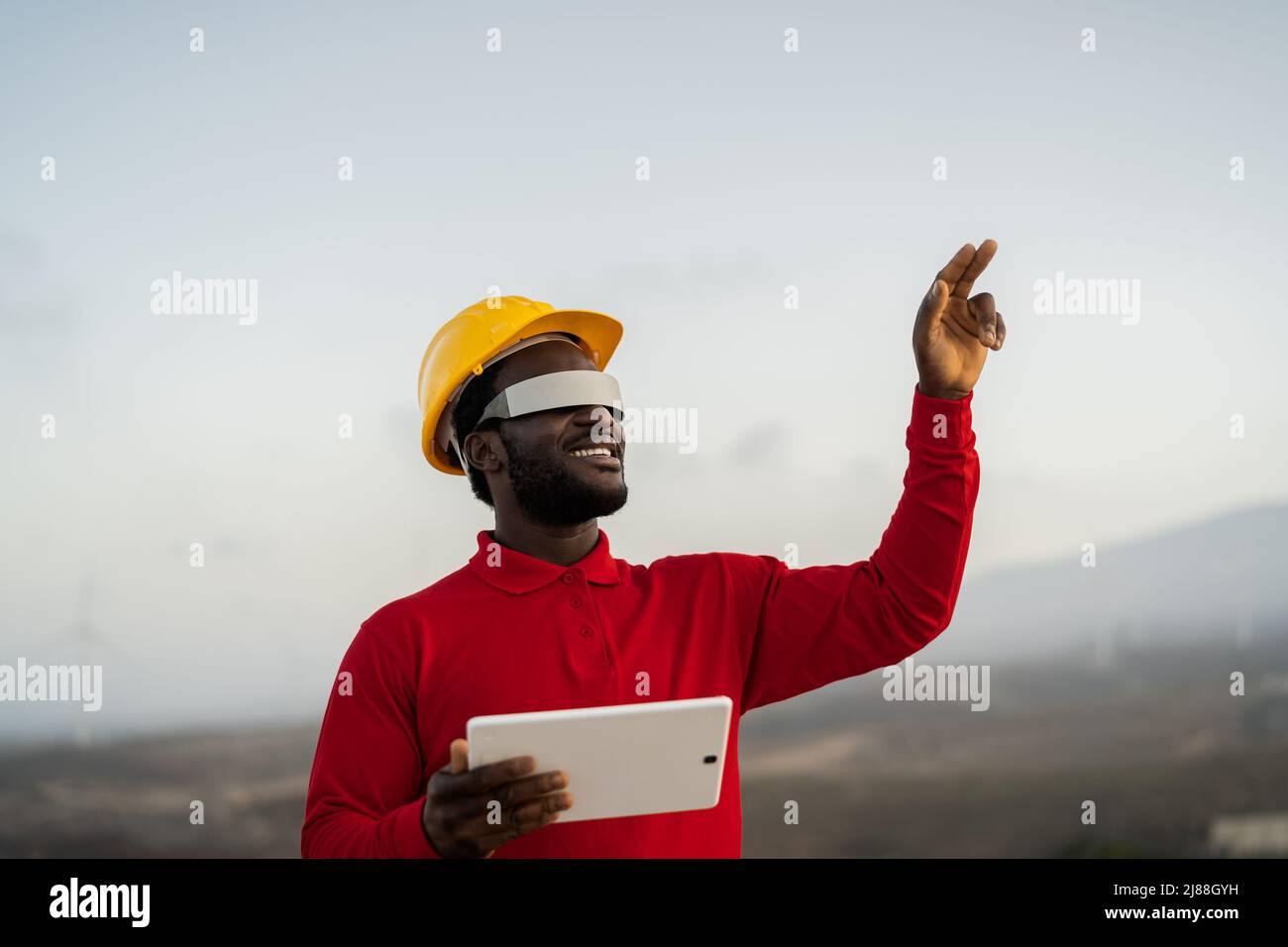 African engineer working with futuristic glasses on construction site ...