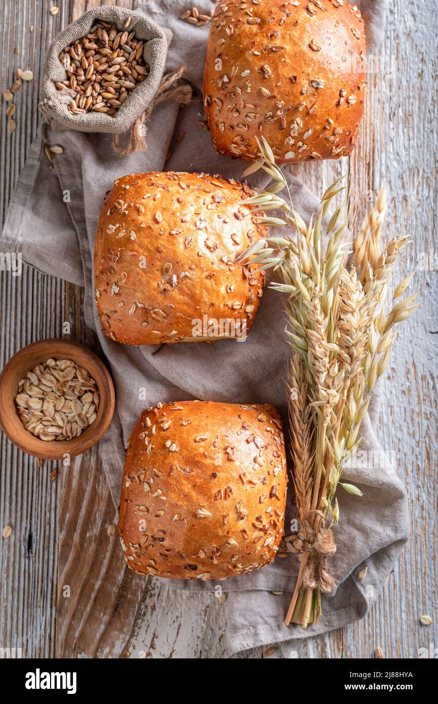 Homemade and hot oat buns with ears of grains. Buns from the bakery ...