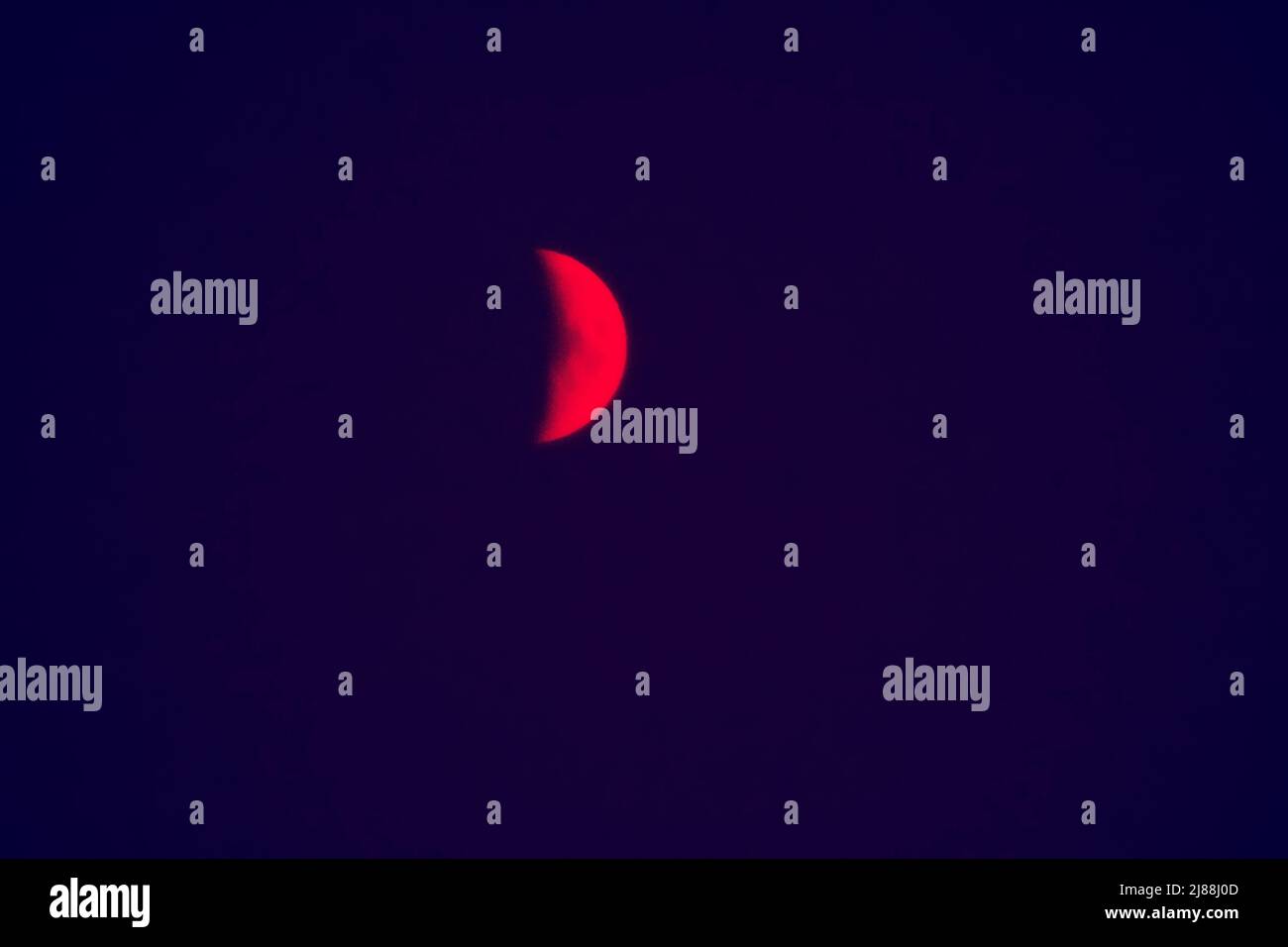 Lamp of Heaven. Waxing half red moon on darl blue sky Stock Photo - Alamy