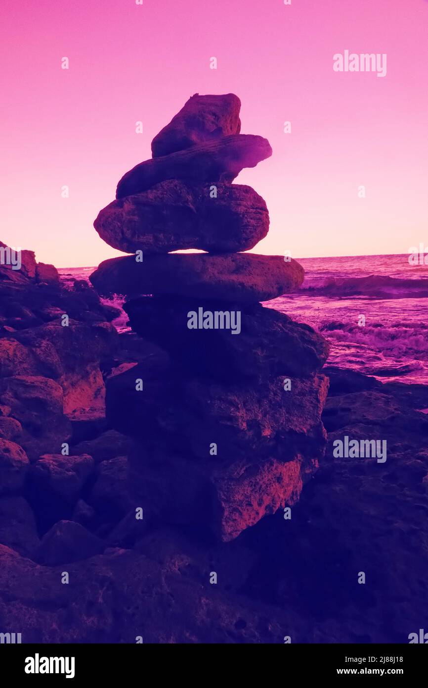 Pyramid of happiness. Flat stones are stacked by beachgoers on the ...