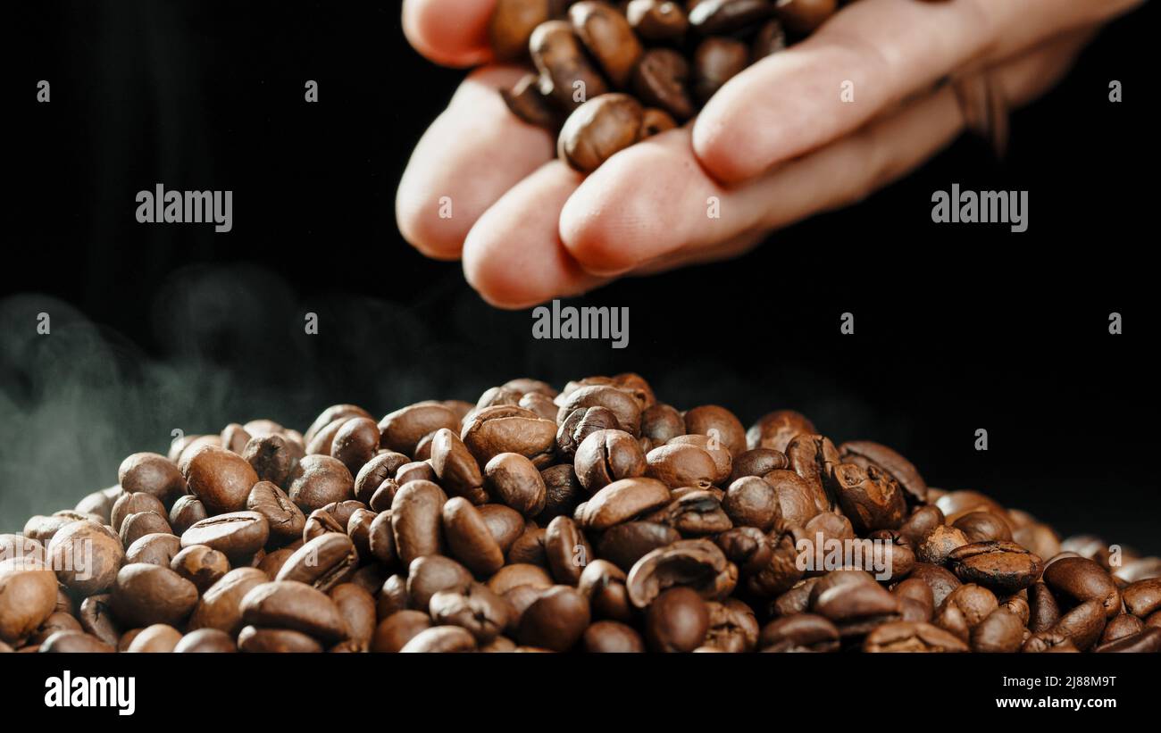 hand touching roasted coffee beans Stock Photo - Alamy