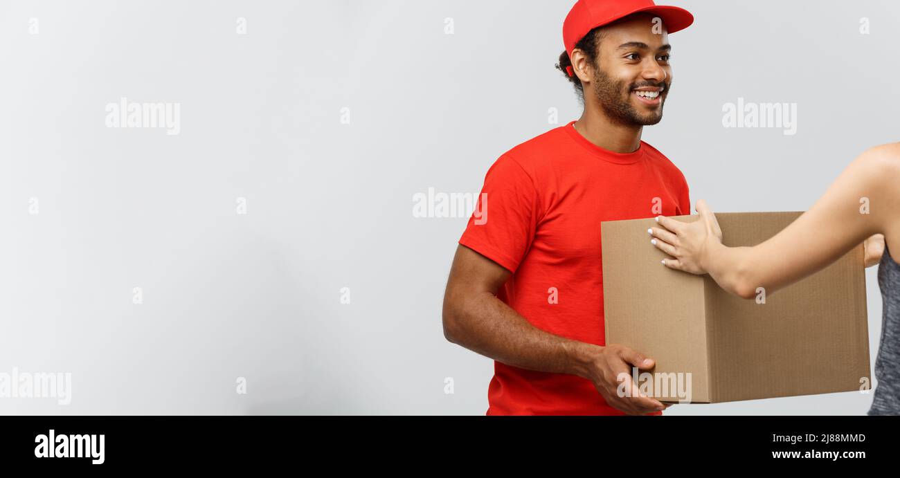 Delivery Concept - Handsome African American delivery man giving package to homeowner. Isolated ...