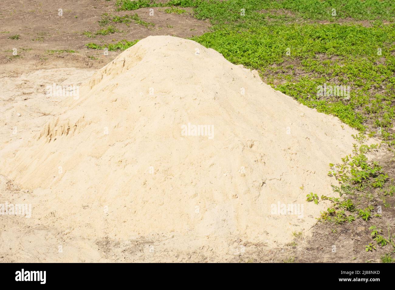 Pile of sand on the ground and grass Stock Photo - Alamy
