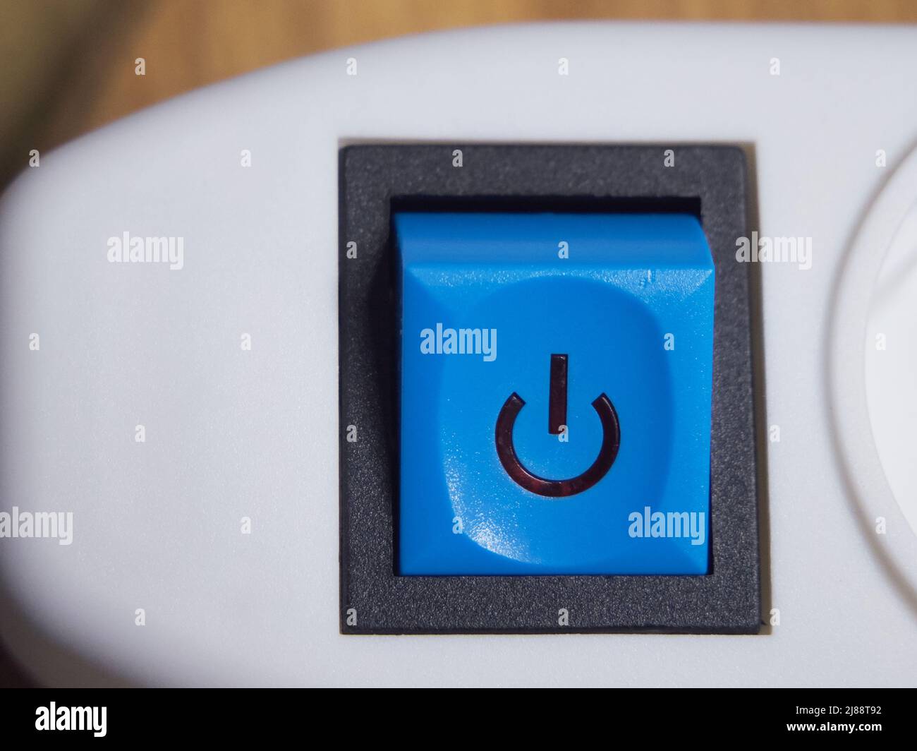 Blue power button on white extension cable. Power button, close-up shot ...