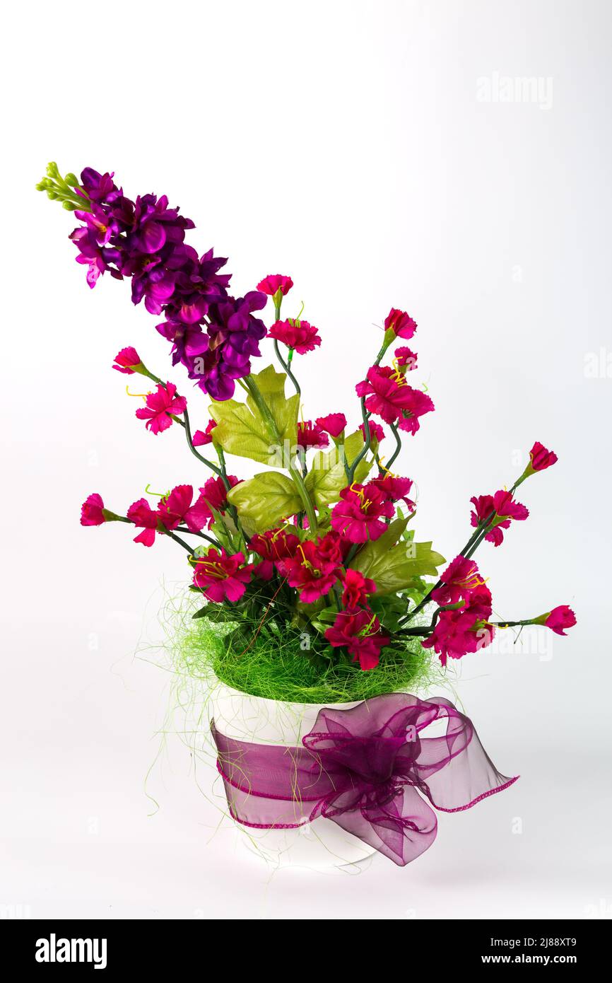 Composition with artificial flowers in a pot on white background ...
