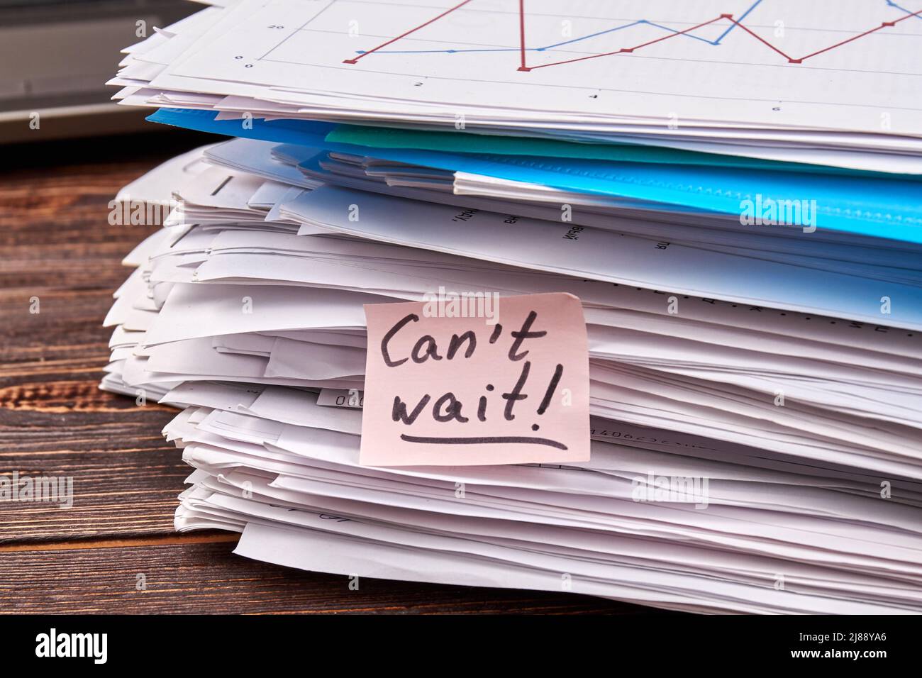 Stack of work papers with sticly note with message. Cant wait concept ...