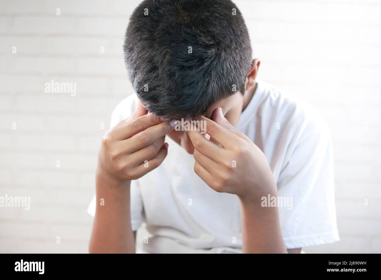 teenage boy covering his face with had Stock Photo - Alamy