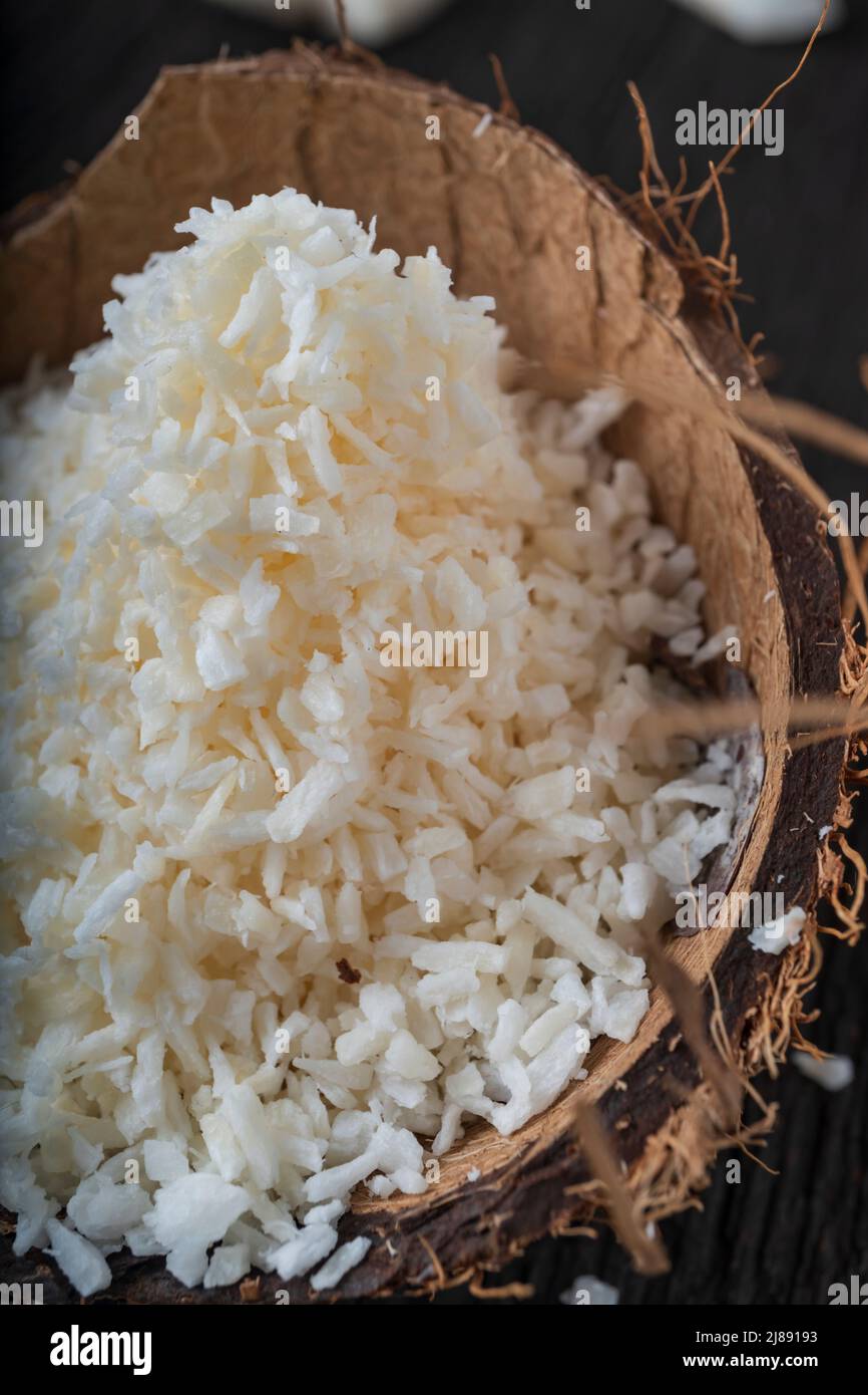 Chopped coconut on a wooden background, top view. Coconut milk and ...