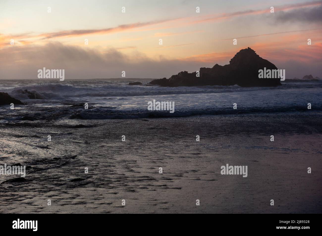 Tidal waves flowing out at Pfeiffer beach, while it is enshrouded by a ...