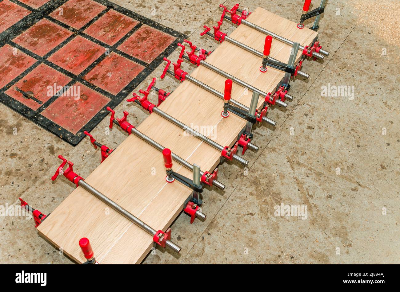 Joiner's clamps on length of bar. Wooden board. Top view Stock Photo ...