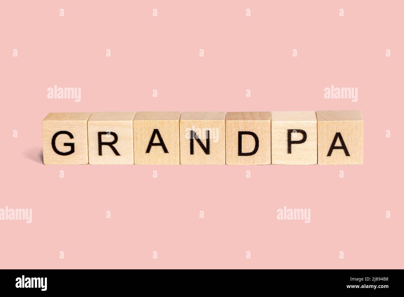 Wooden cubes with the word Grandpa on pastel pink background with copy ...