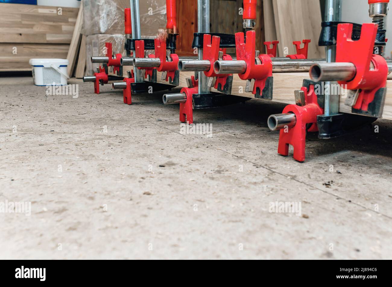 Wooden board in carpentry workshop. Joiner's clamp. Wood shavings ...