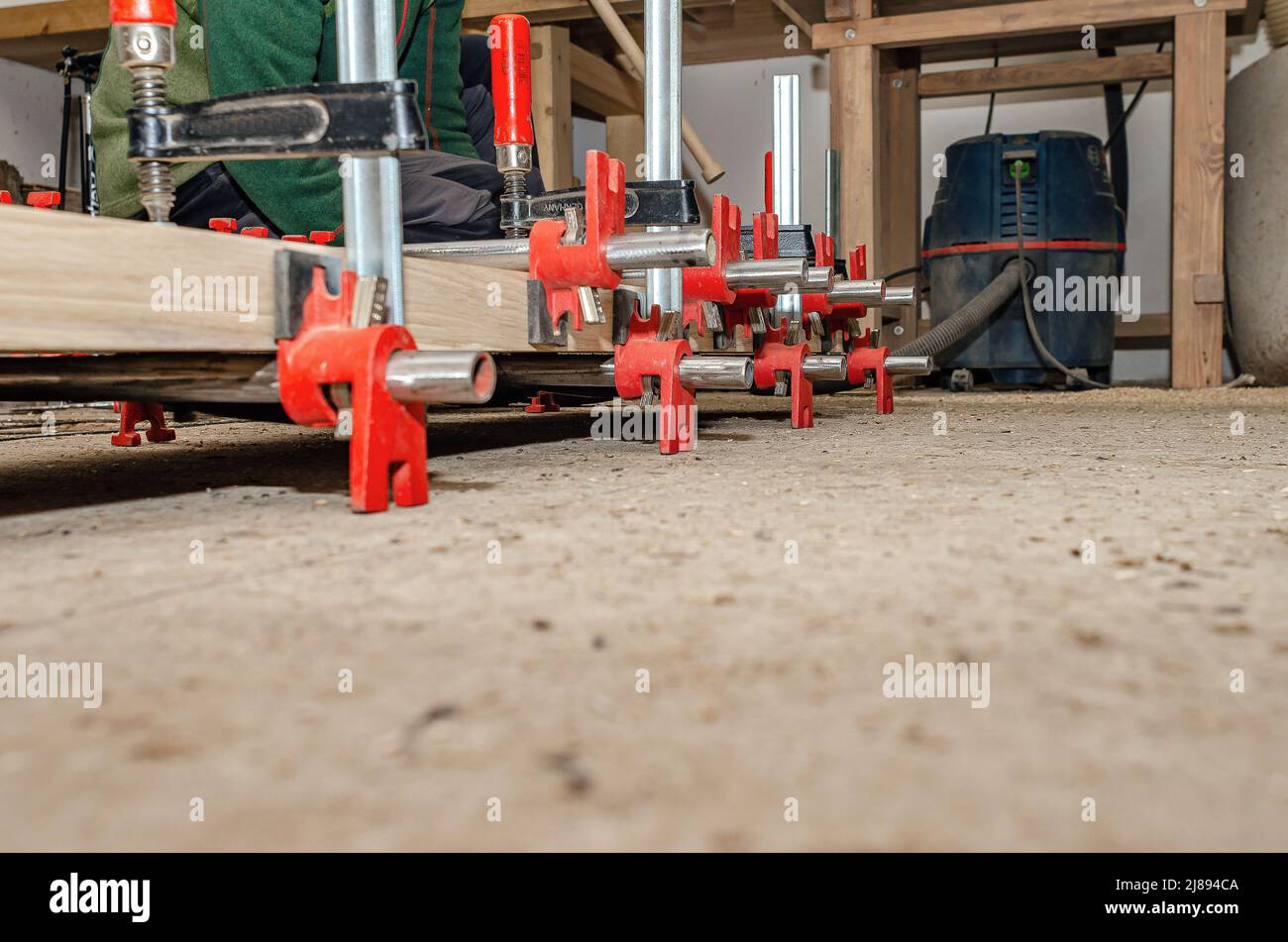 Wooden board in carpentry workshop. Joiner's clamp. Wood shavings ...
