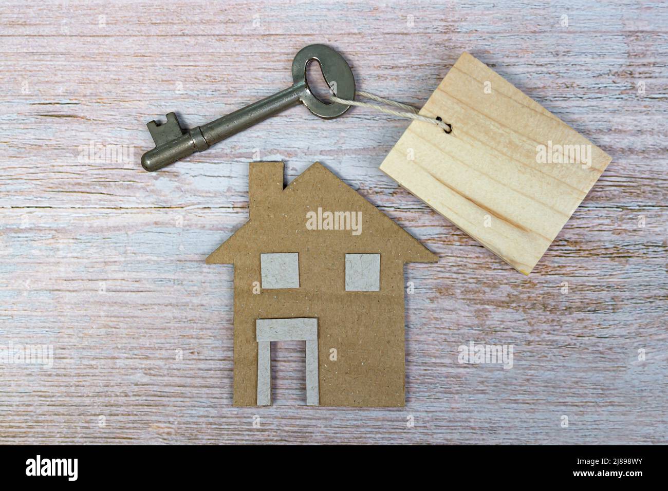 House model and key on wooden desk. Directly above. Flat lay for text ...