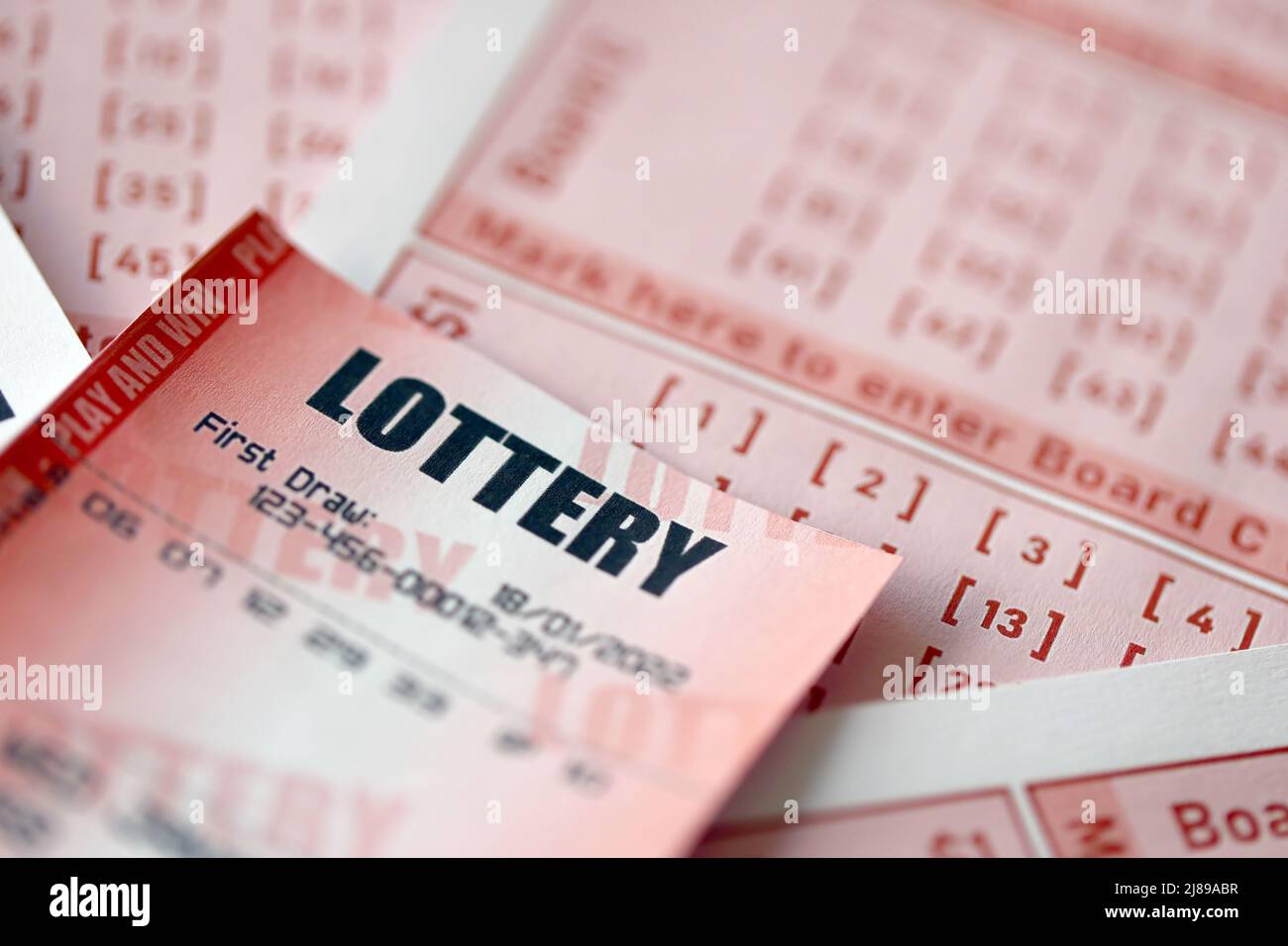 Red lottery ticket lies on pink gambling sheets with numbers for ...