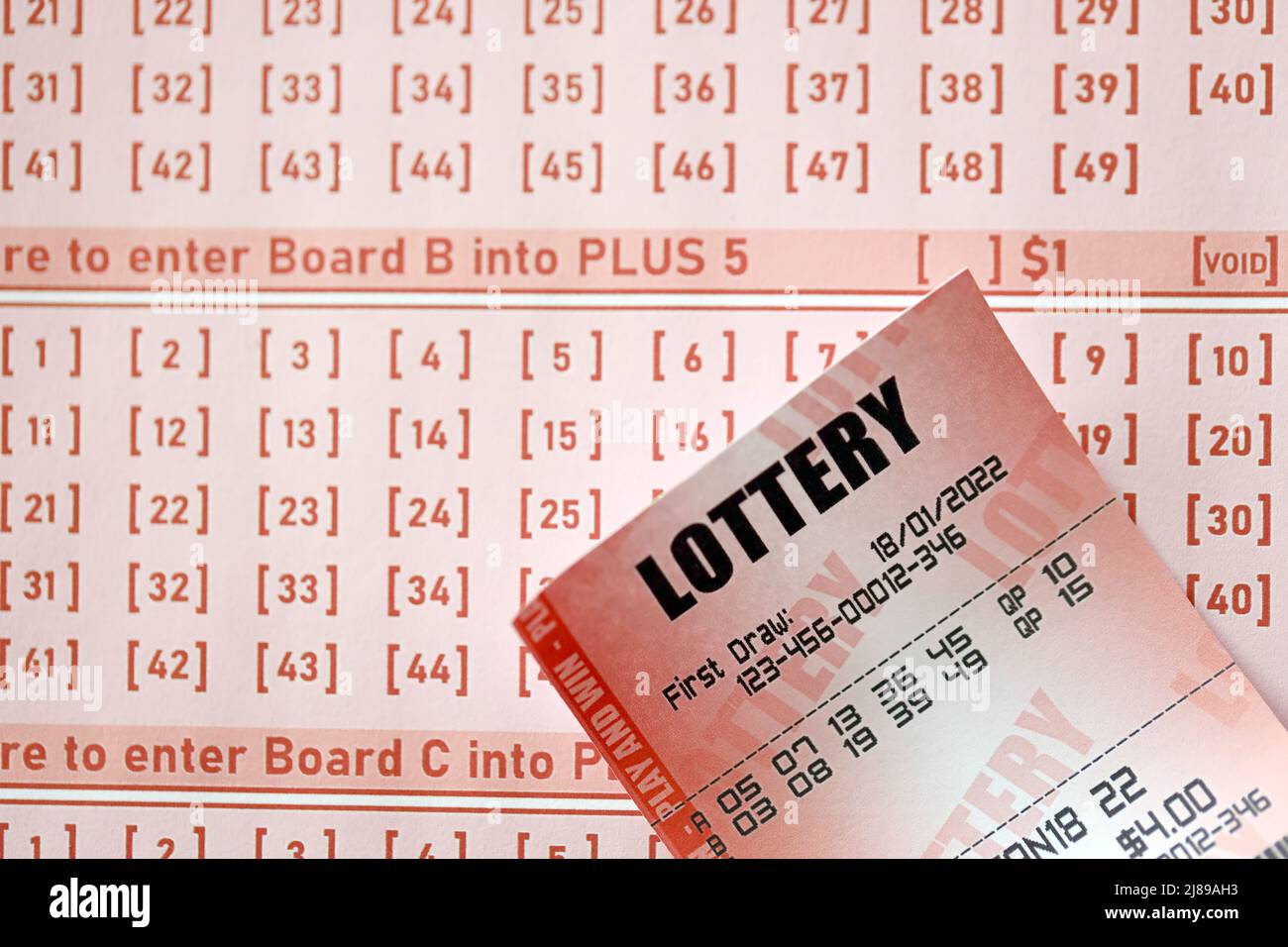 Red lottery ticket lies on pink gambling sheets with numbers for ...