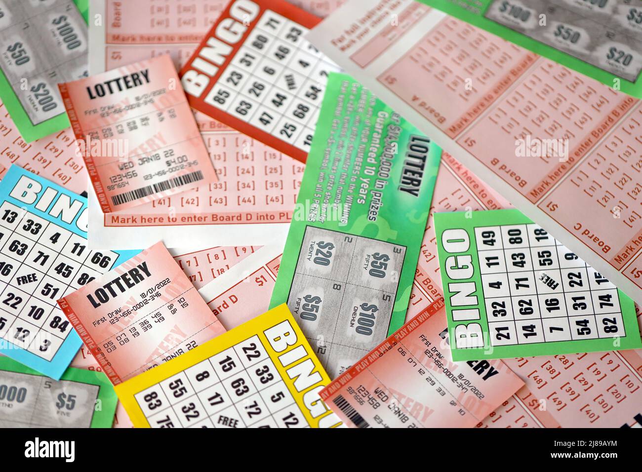 Many used lottery tickets, bills with numbers and bingo playing boards ...