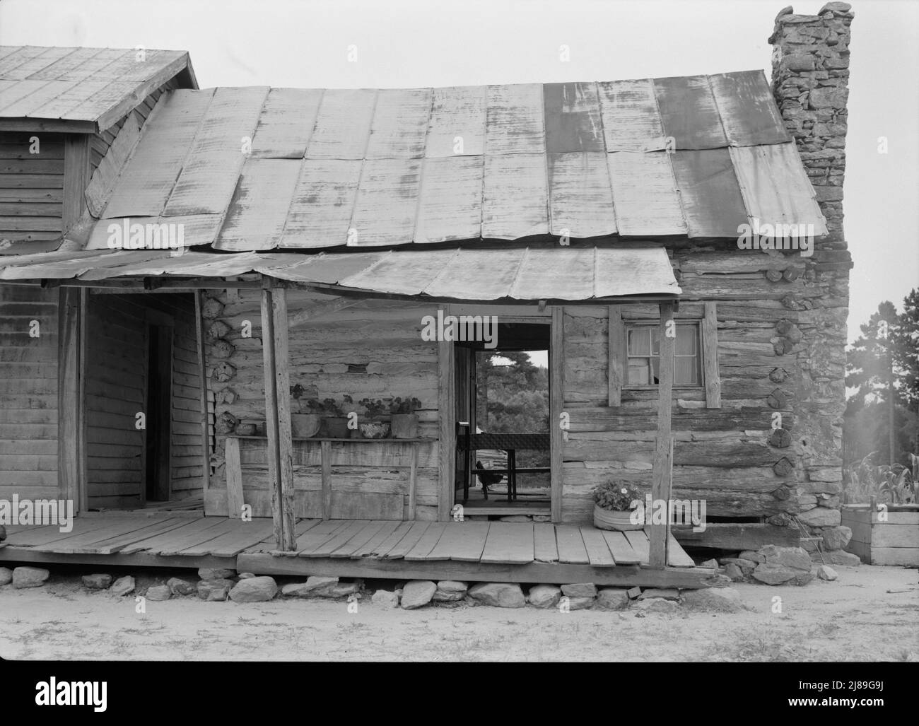 Negro sharecropper house on dirt. Dirt log cabin on right is much older ...