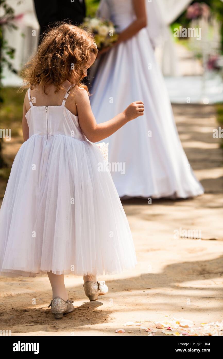 The little girl and brides at the outdoor ceremony Stock Photo - Alamy