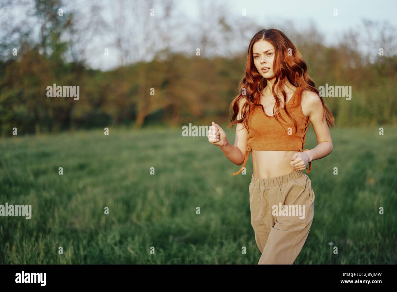 A woman is jogging with a focused face, tired after an outdoor activity ...